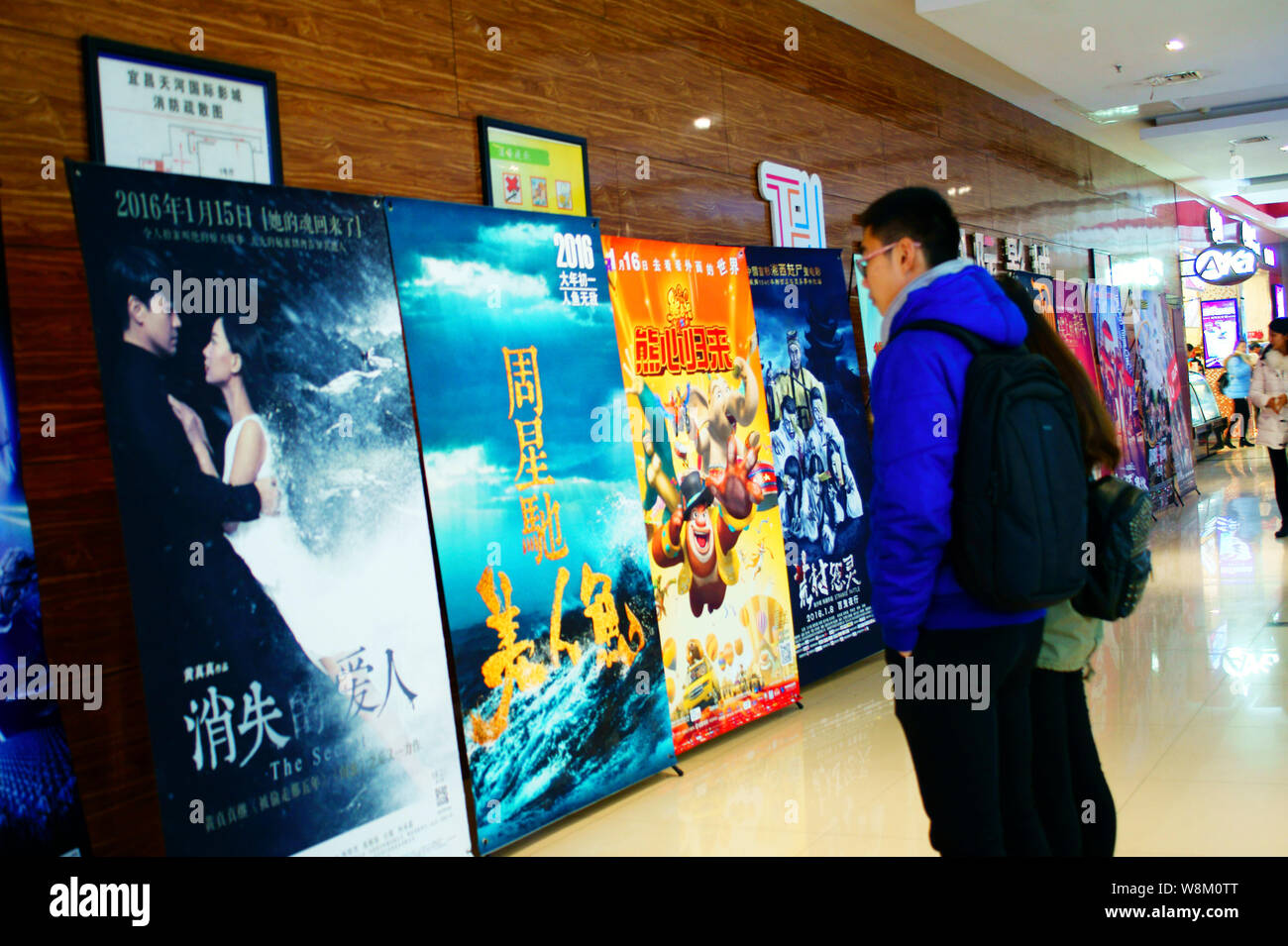 --FILE--A Chinese filmgoer looks at posters of movies at a cinema in ...