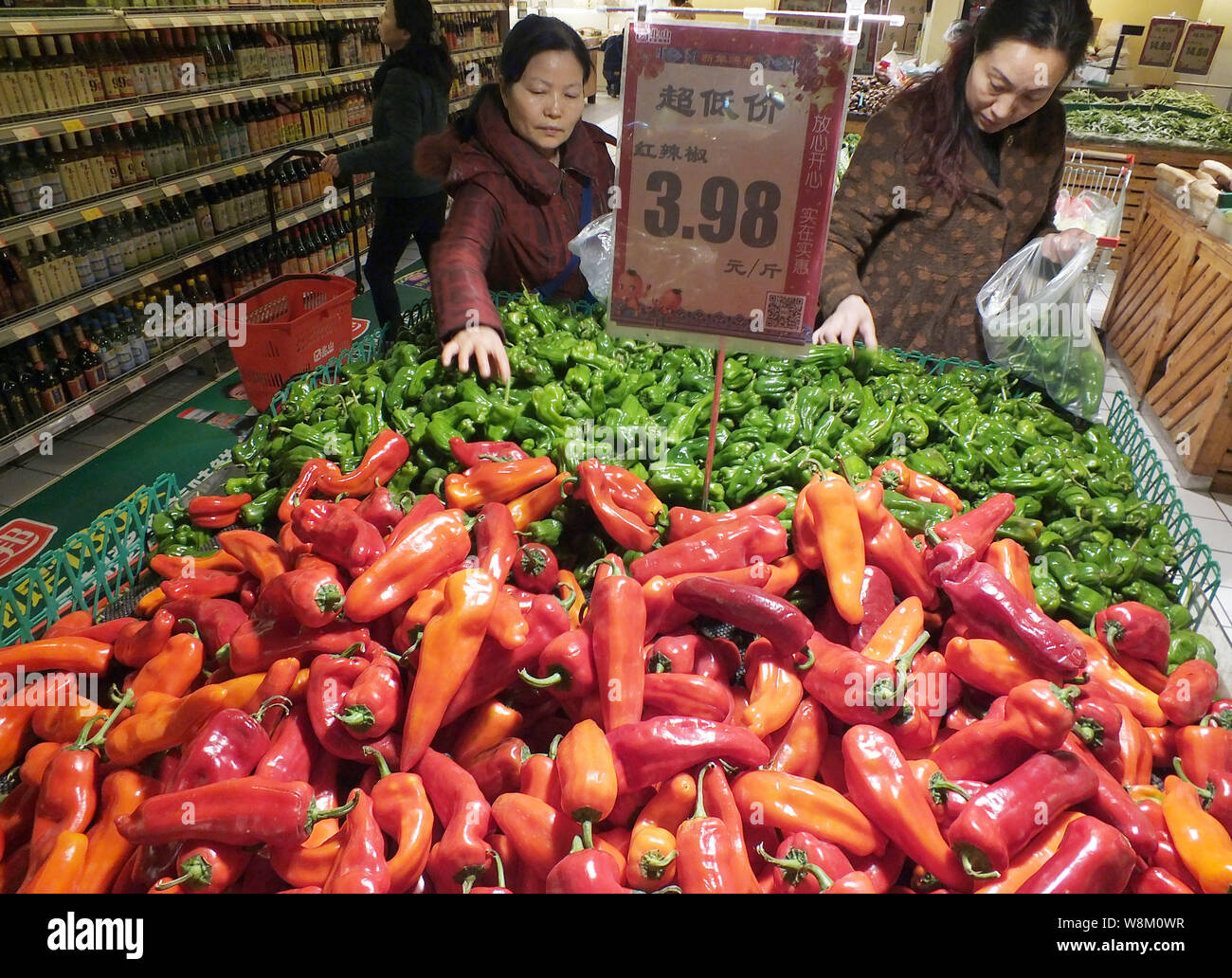 Chinese customers shop for peppers at a supermarket in Yichang city ...