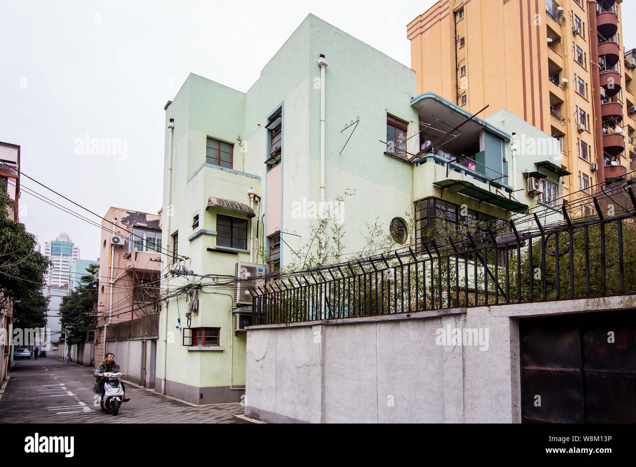 A Chinese man rides his eletric bike in a lilong (alley or lane in ...