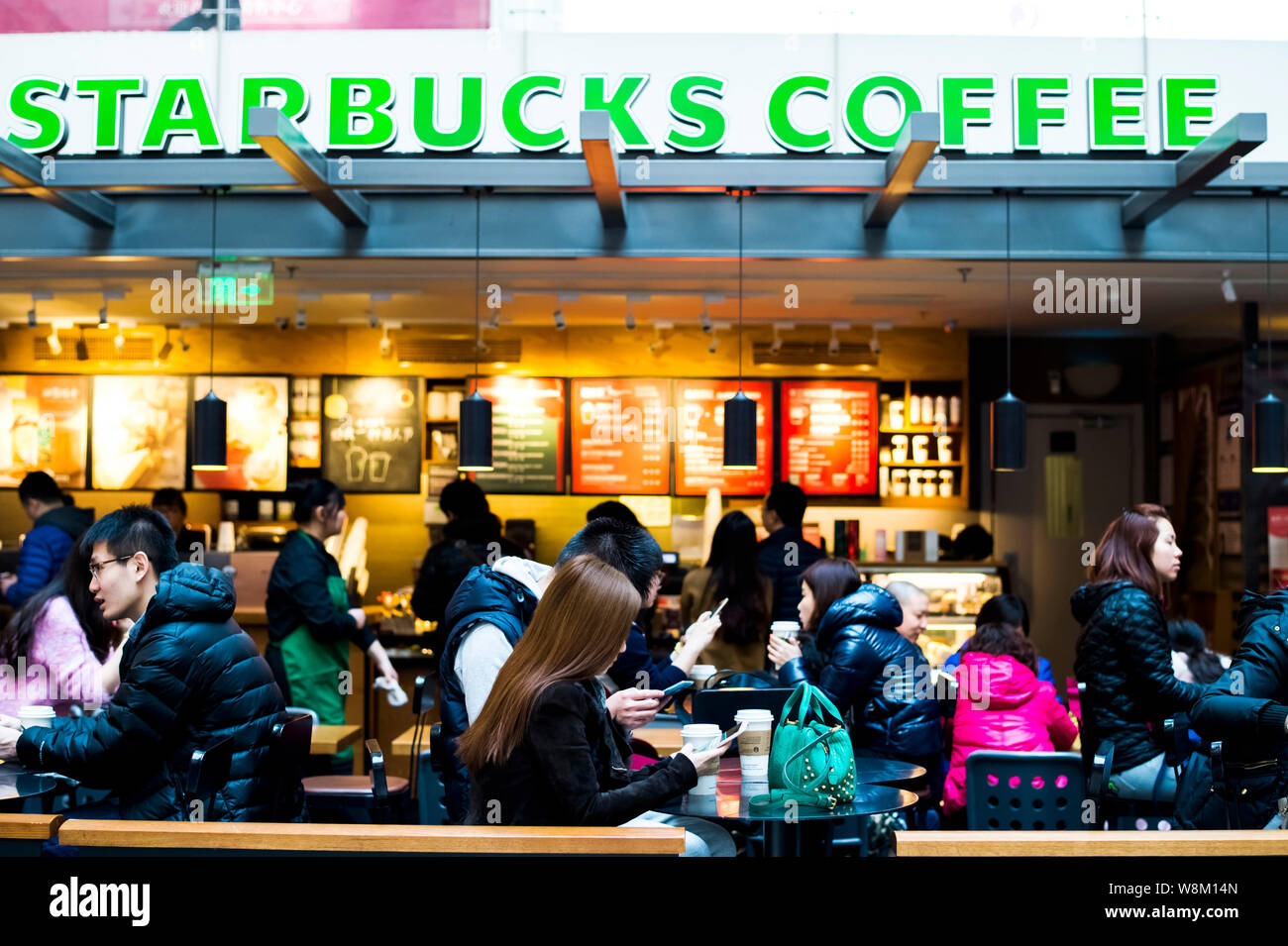 Chinese customers enjoy coffee at a cafe of Starbucks Coffee in Beijing ...