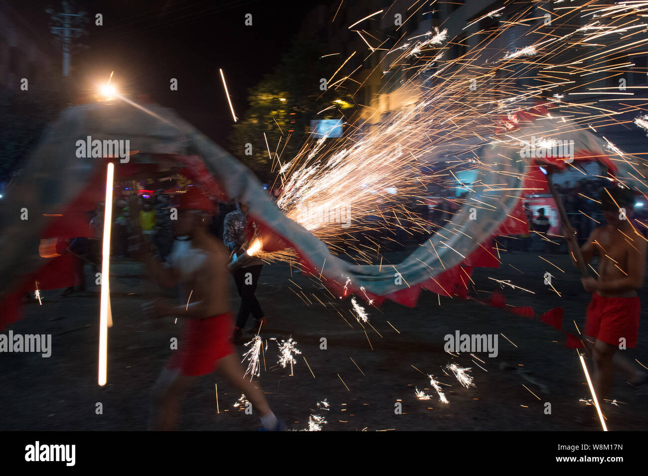 Chinese entertainers perform a dragon dance in sparks of fireworks to ...