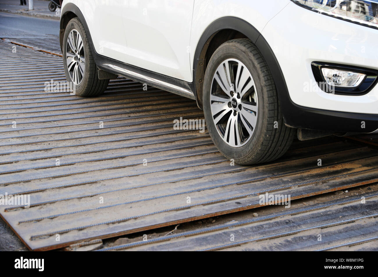 A car travels on steel plates with rebar on a road in Zhengzhou city ...