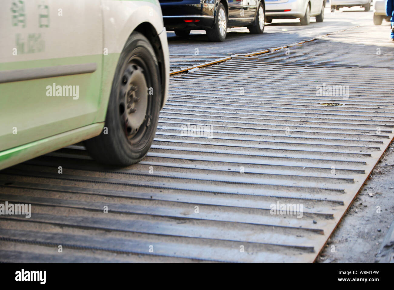 A car travels on steel plates with rebar on a road in Zhengzhou city ...