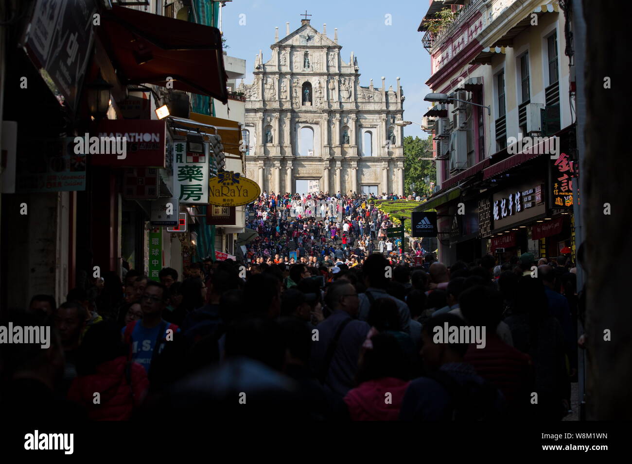 Tourists crowd a lane in front of the Ruins of St. Paul's during the ...
