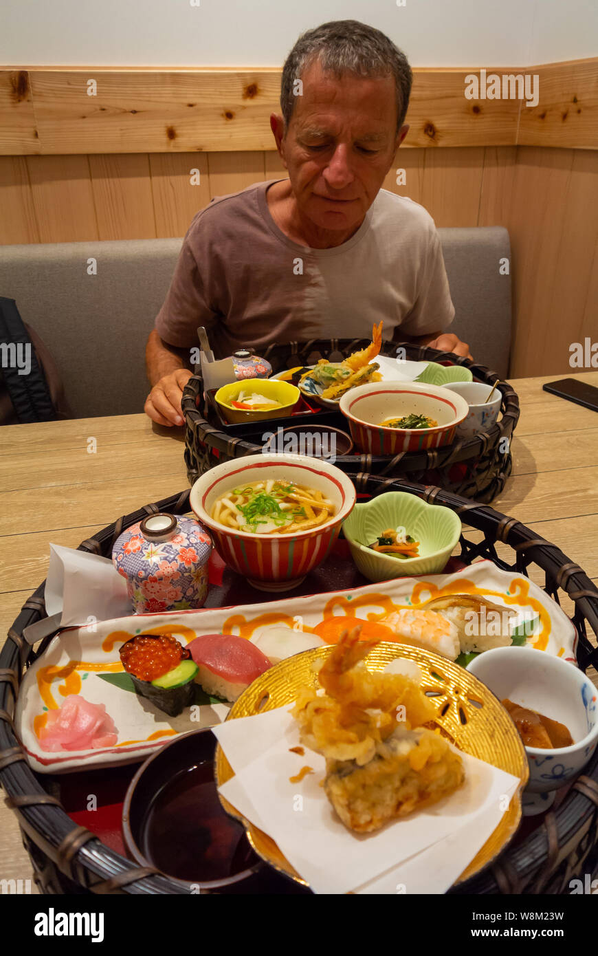A foreign male tourist eating a japanese set menu at a restaurant ...