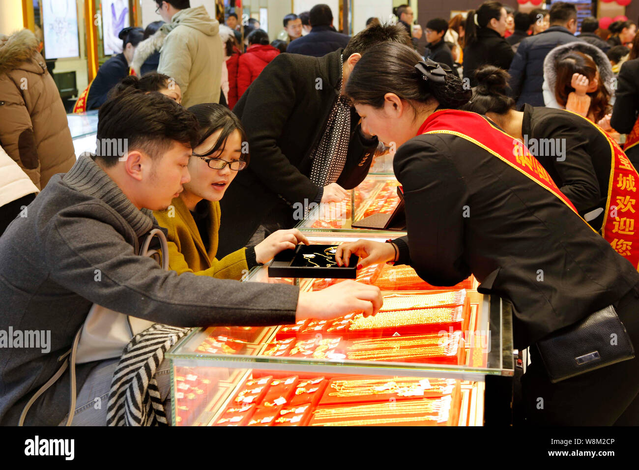 --FILE--Chinese customers shop for gold ornaments at a jewelry store in ...