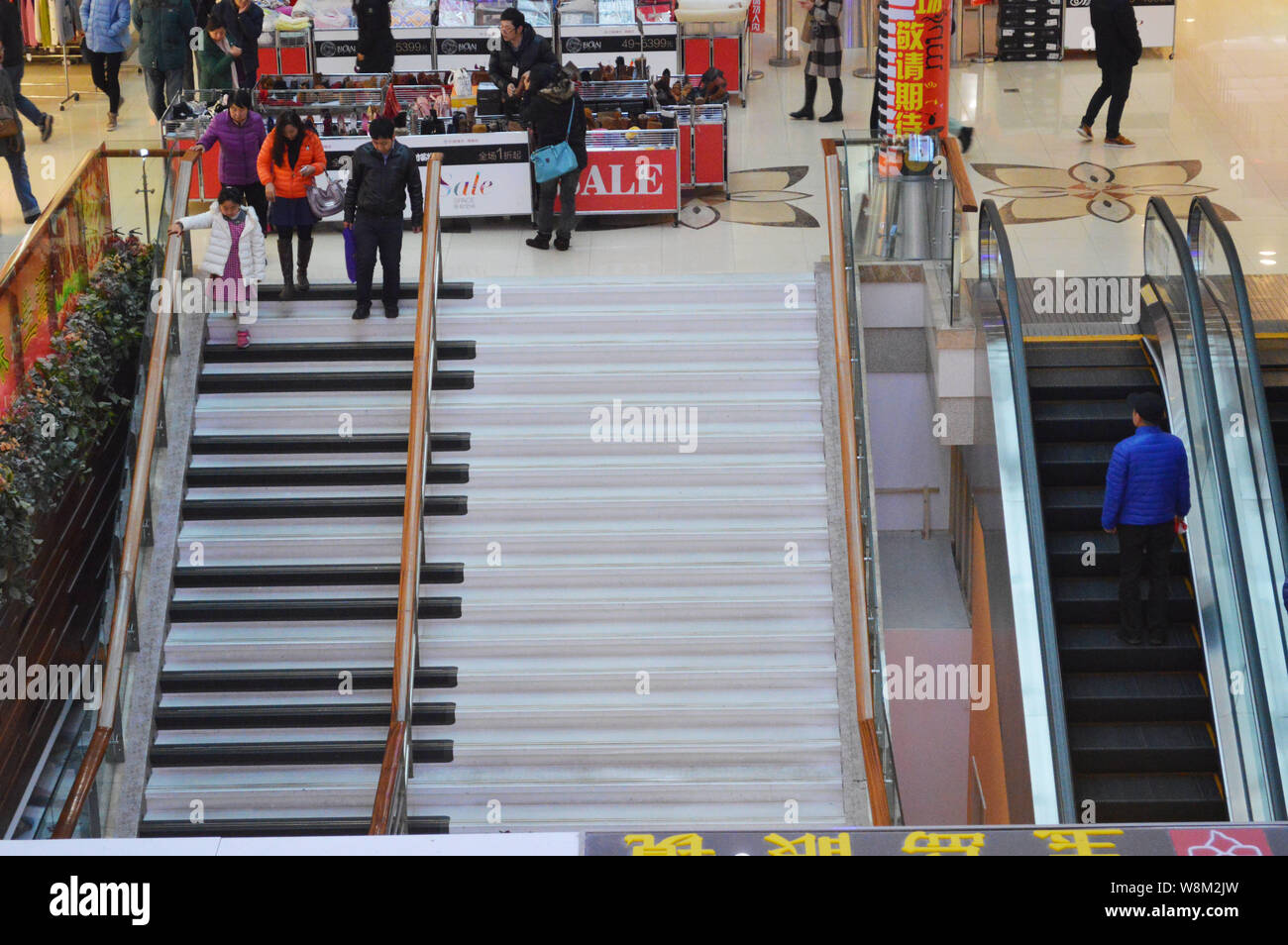 Chinese customers walk on a "piano staircase", which plays musical ...