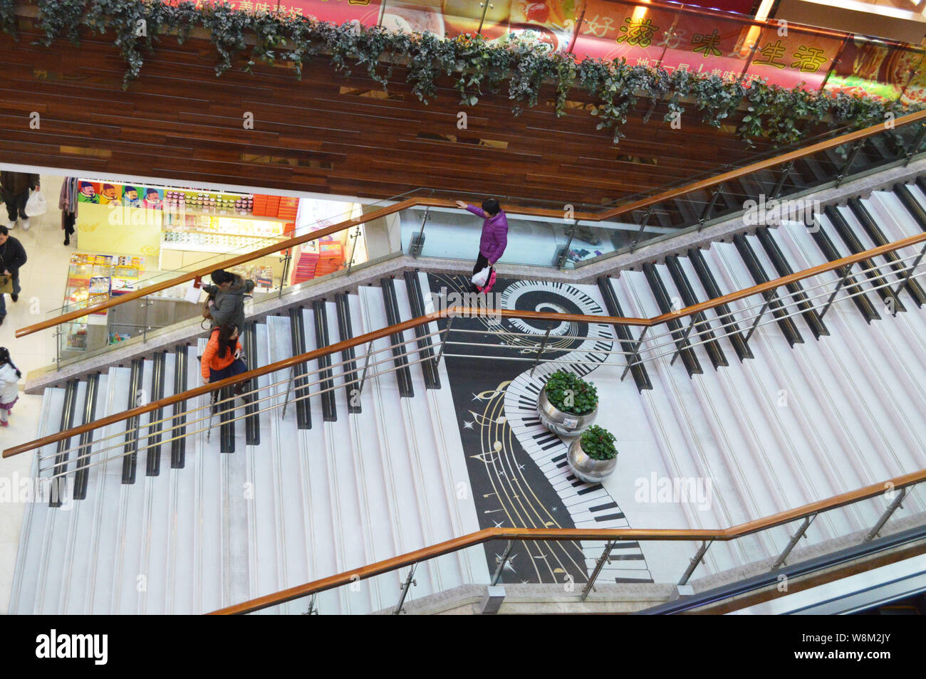 Chinese customers walk on a "piano staircase", which plays musical ...