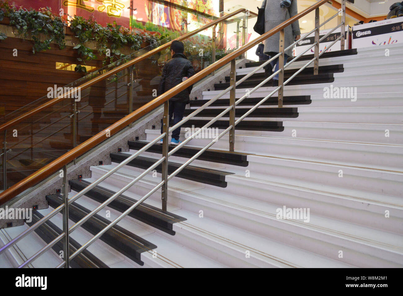 Chinese customers walk on a "piano staircase", which plays musical ...