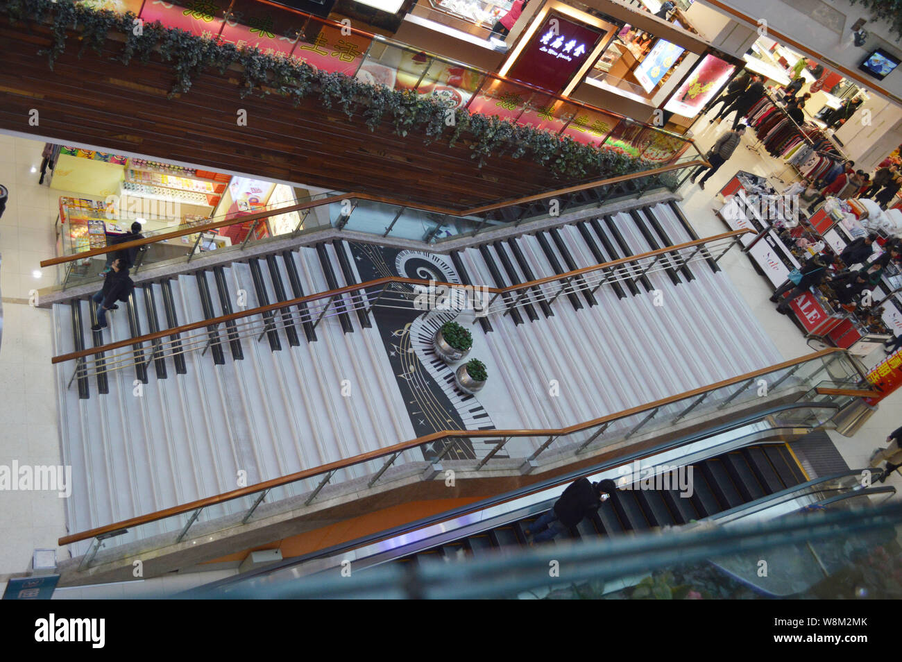 Chinese customers walk on a "piano staircase", which plays musical ...