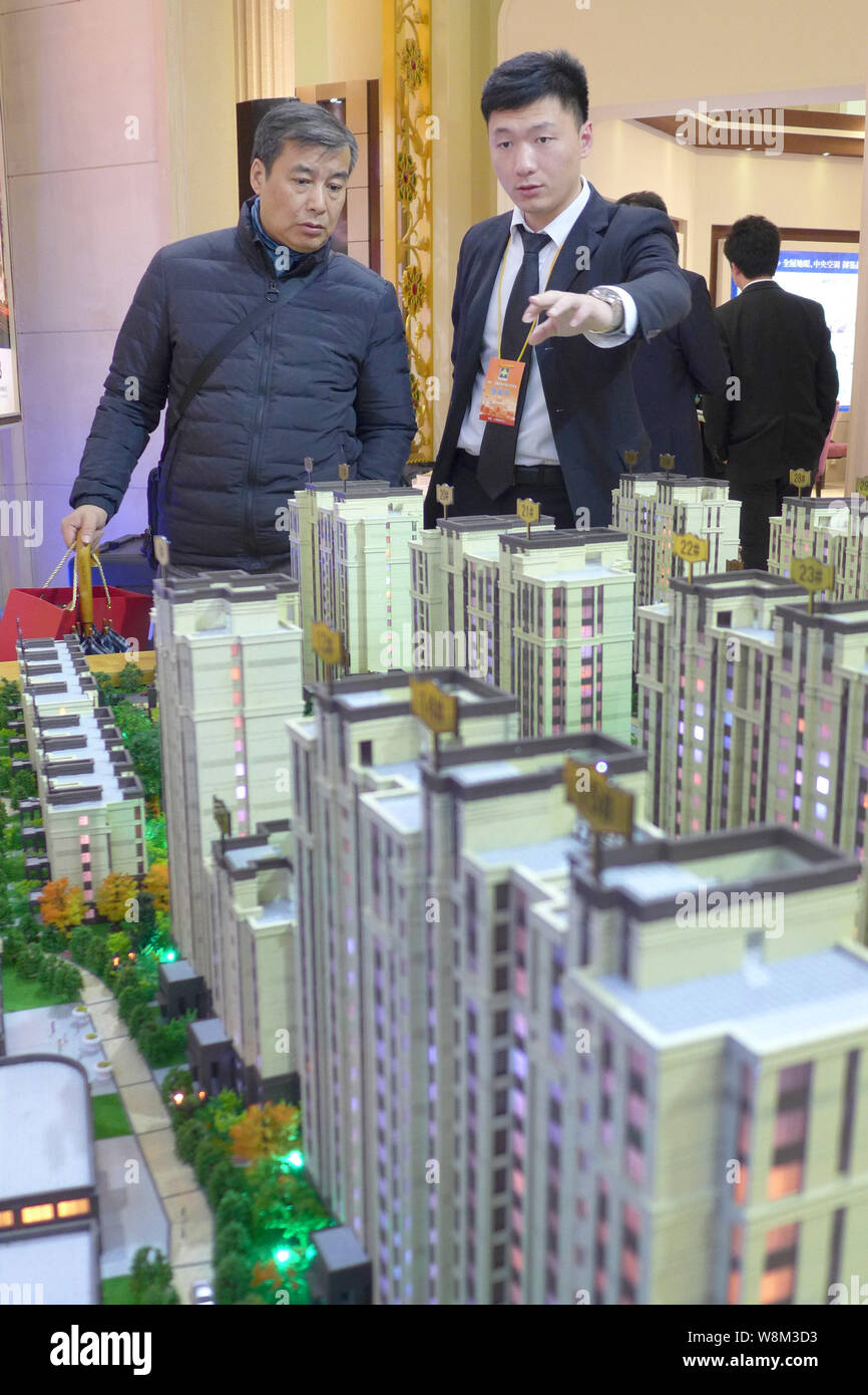 --FILE--A Chinese employee introduces models of residential apartment ...