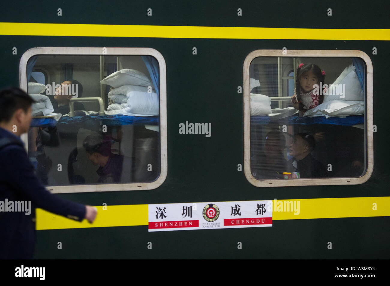 Chinese passengers are pictured in a train as they are going back home ...