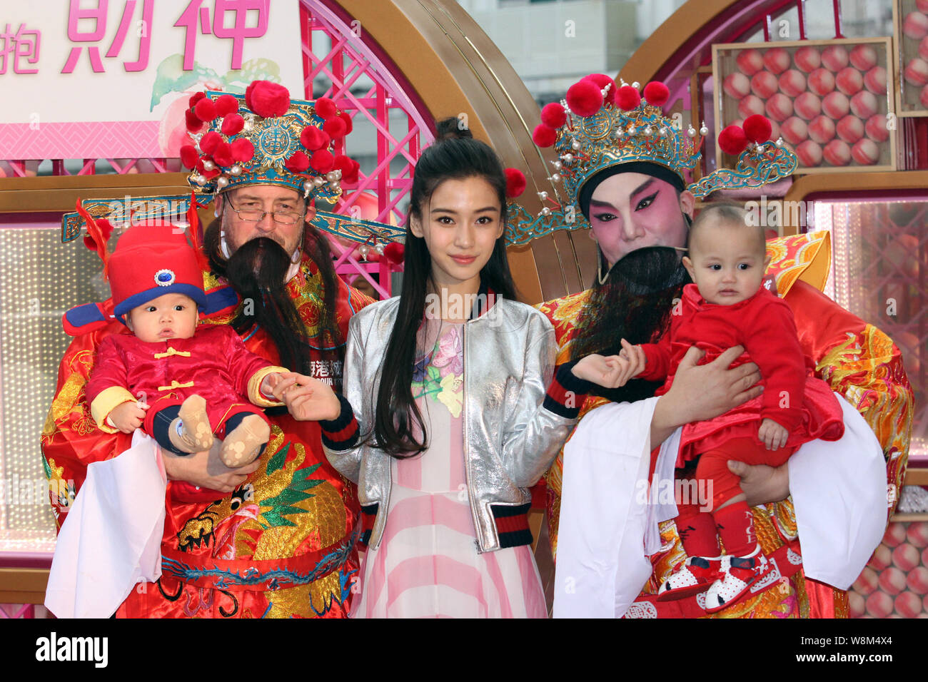 Hong Kong model and actress Angelababy, center, poses with babies held ...