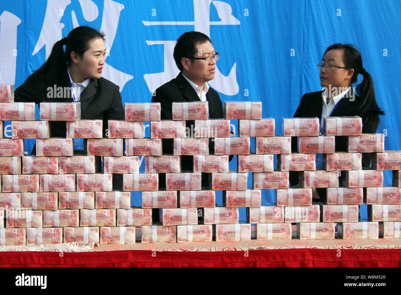 Chinese employees prepare stacks of 100-yuan RMB (Renminbi) banknotes ...