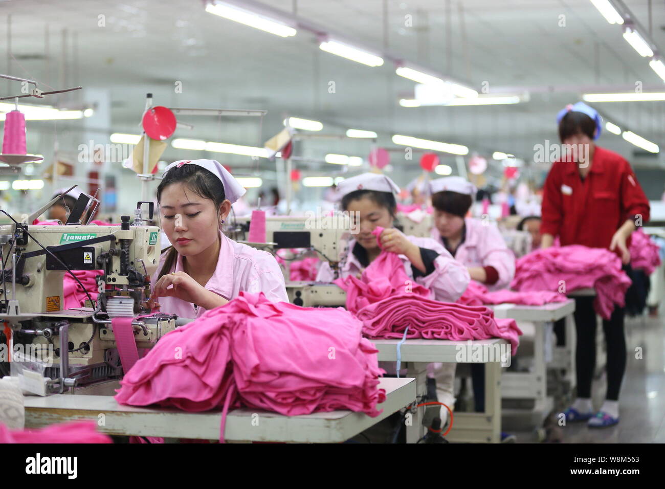 --FILE--Female Chinese workers sew clothes at a garment factory in Jimo ...