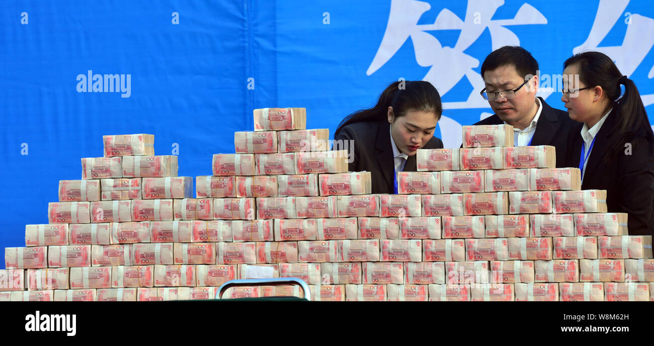 Chinese employees prepare stacks of 100-yuan RMB (Renminbi) banknotes ...