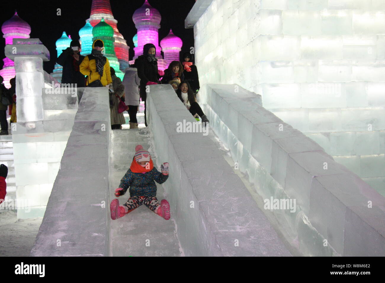 Tourists enjoy slides on ice slideways during the 32nd Harbin ...