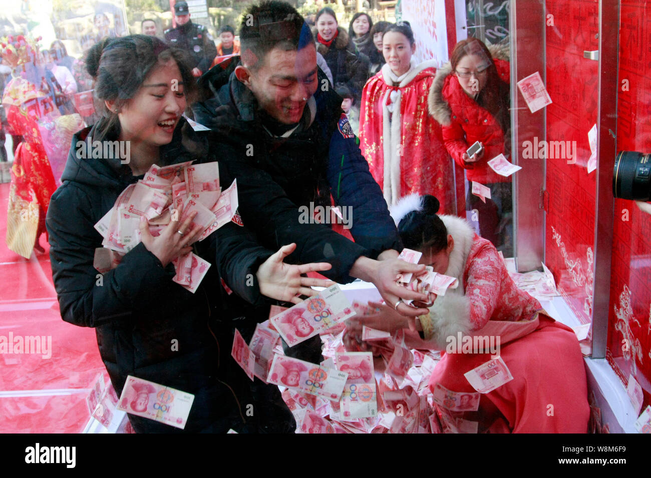 Chinese tourists try to grab 100-yuan banknotes as many as they can in ...