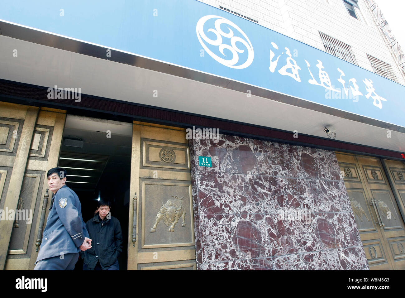 --FILE--A Chinese security guard stands at the door as investors exit ...