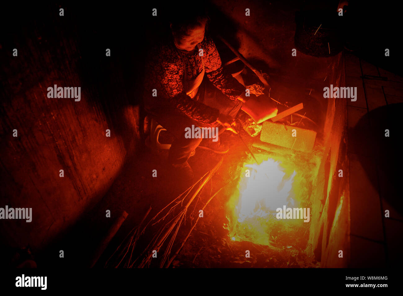 A Chinese villager burns a piece of skin from a butchered pig in fire ...