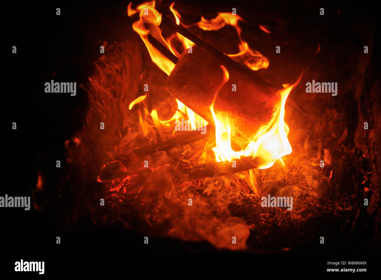 A piece of skin from a butchered pig is burned in fire for its ...