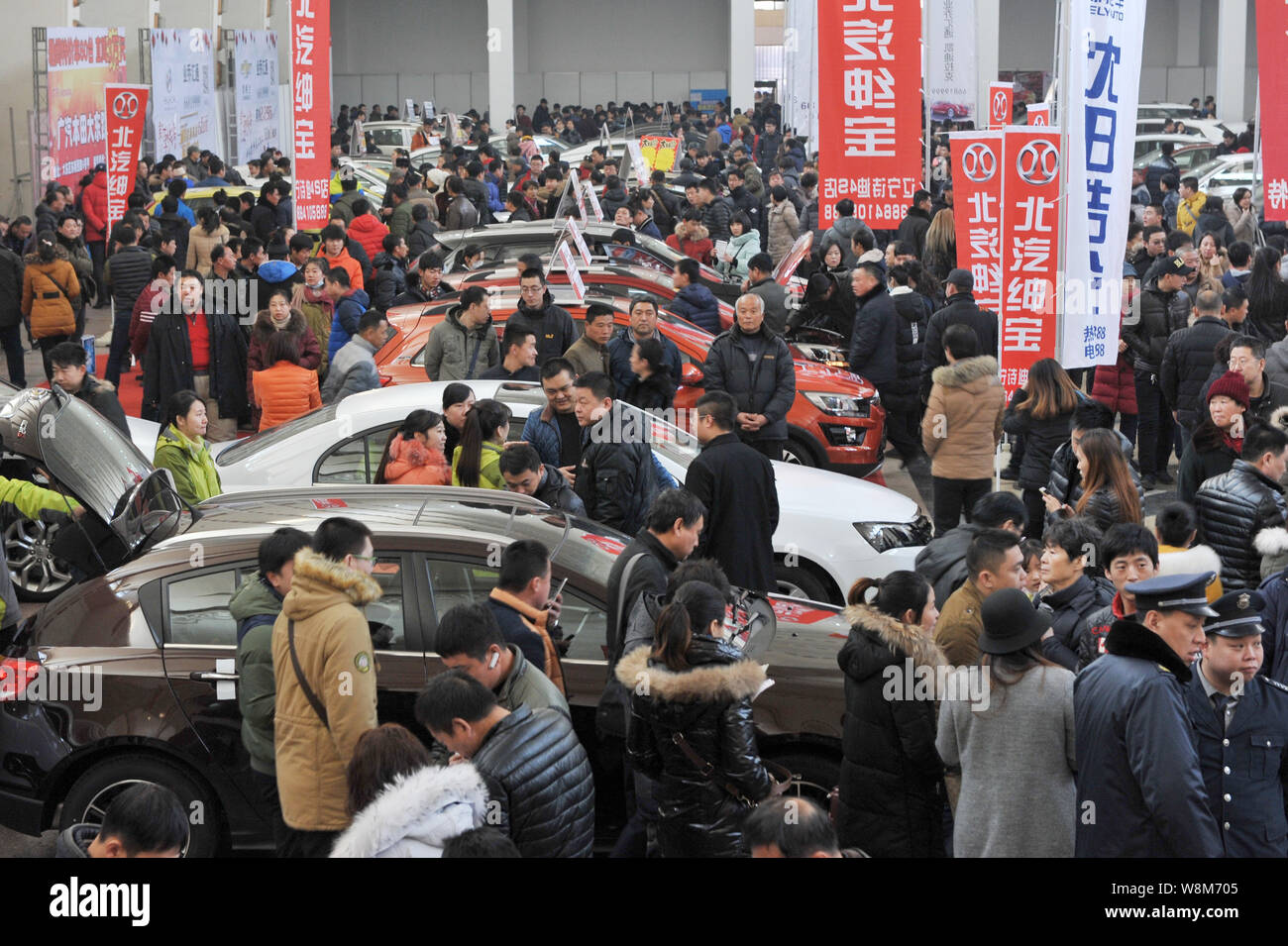 Chinese visitors look at cars on display during an auto show in ...