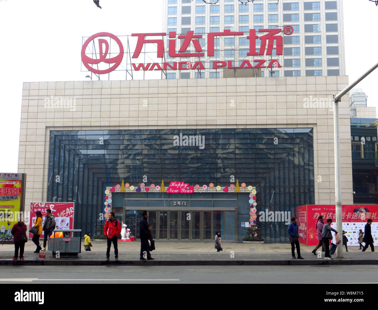 --FILE--Pedestrians walk past a Wanda Plaza of Dalian Wanda Group in ...