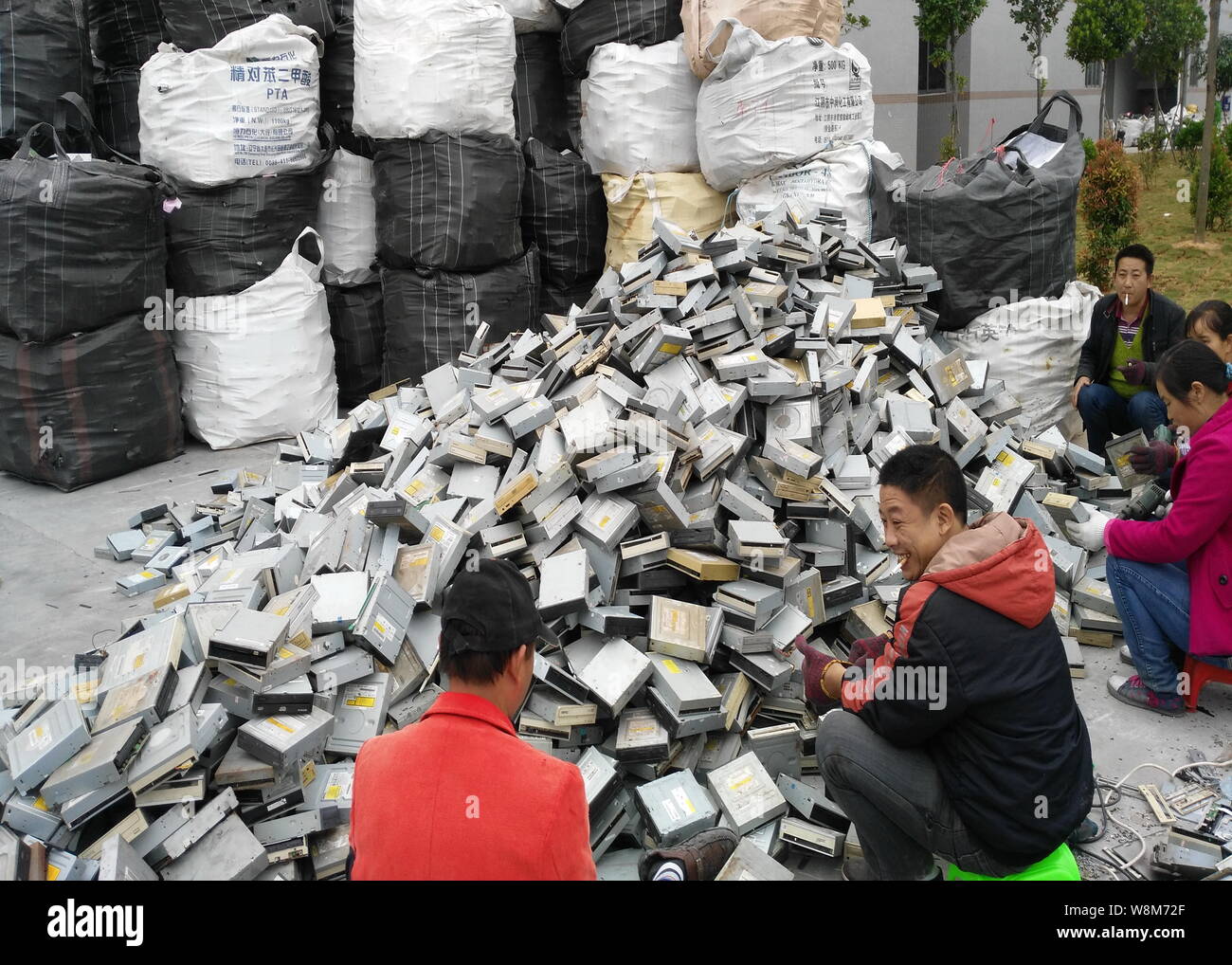 Chinese workers remove components from hard drives of computers at a ...