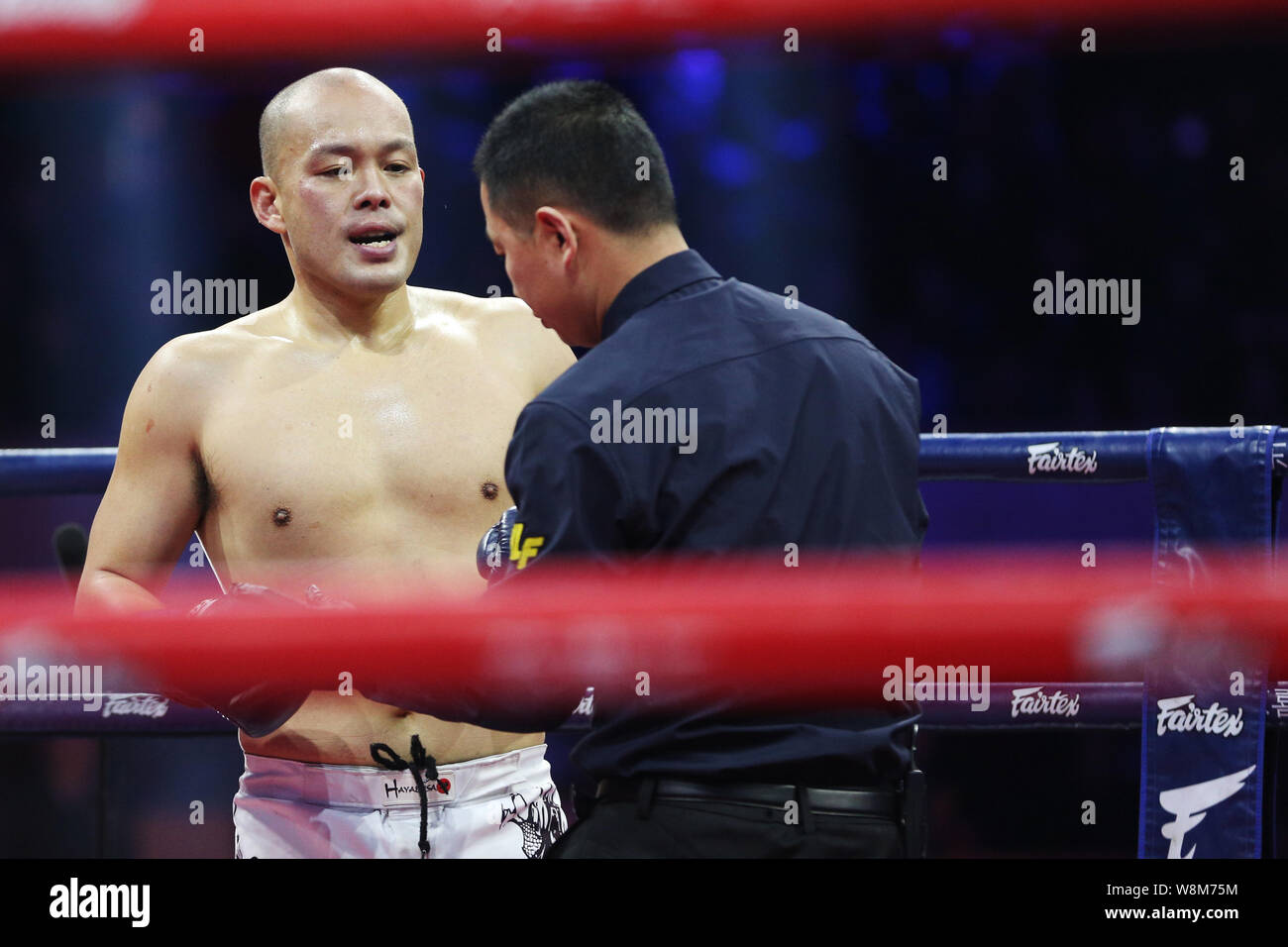 A referee checks checks Japanese boxer KING as he fights Chinese boxer ...