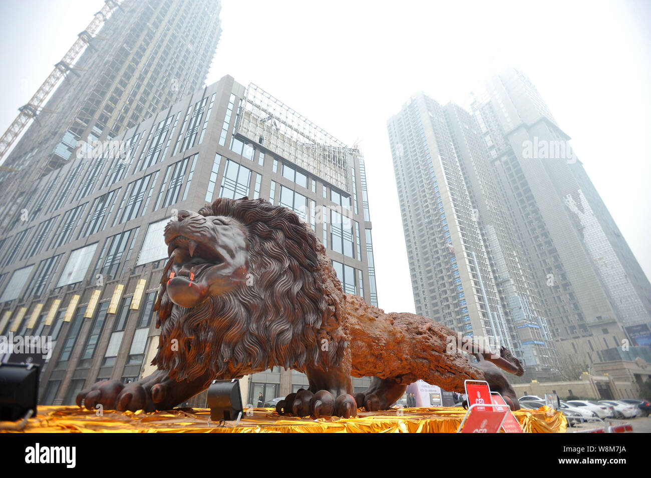 A lion sculpture made of Myanmar rosewood is on display on a square in ...