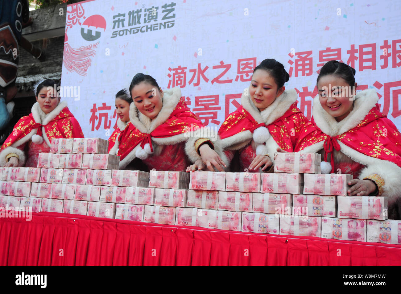 Chinese hostesses stack up bundles of 100-yuan RMB (renminbi) yuan ...