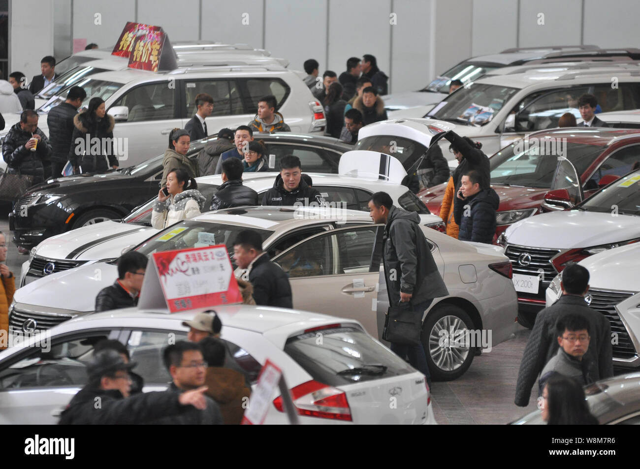 --FILE--Visitors look at cars during an automobile exhibition in ...