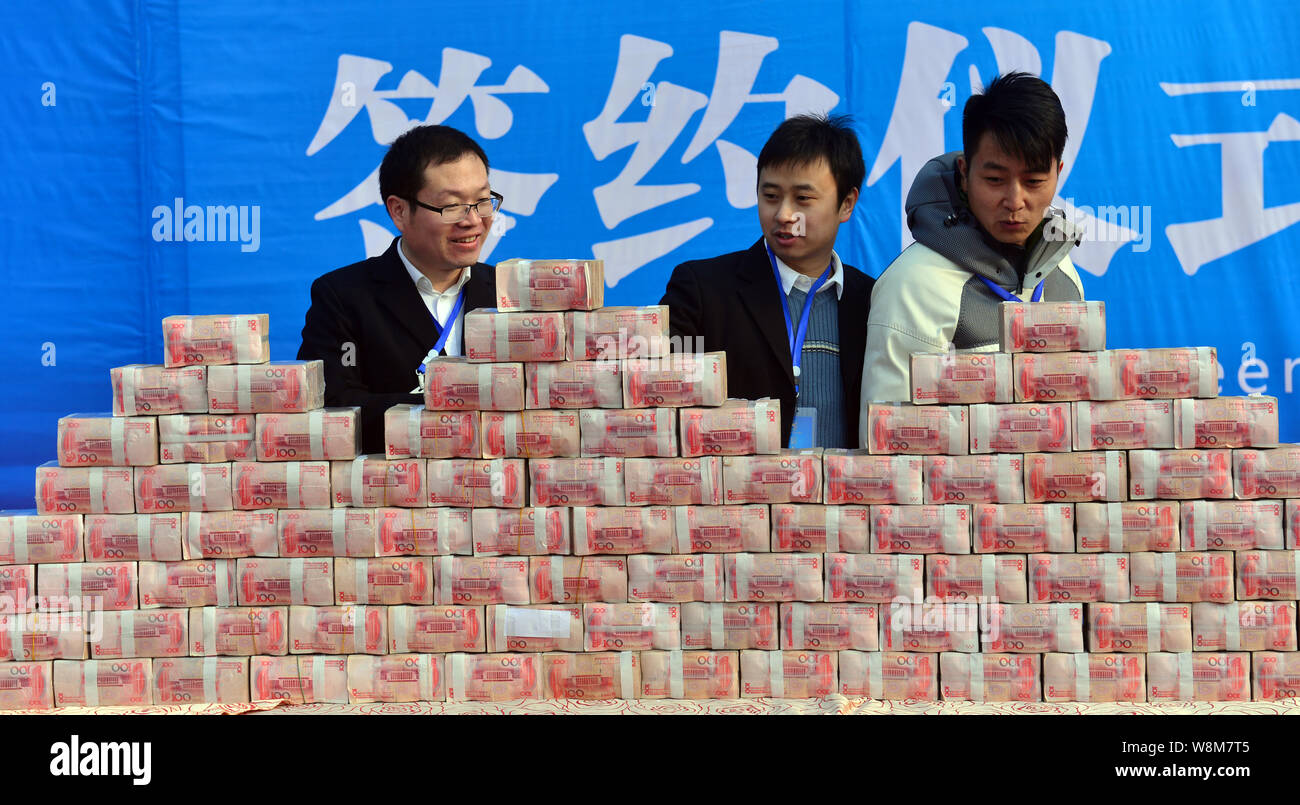 Chinese employees prepare stacks of 100-yuan RMB (Renminbi) banknotes ...