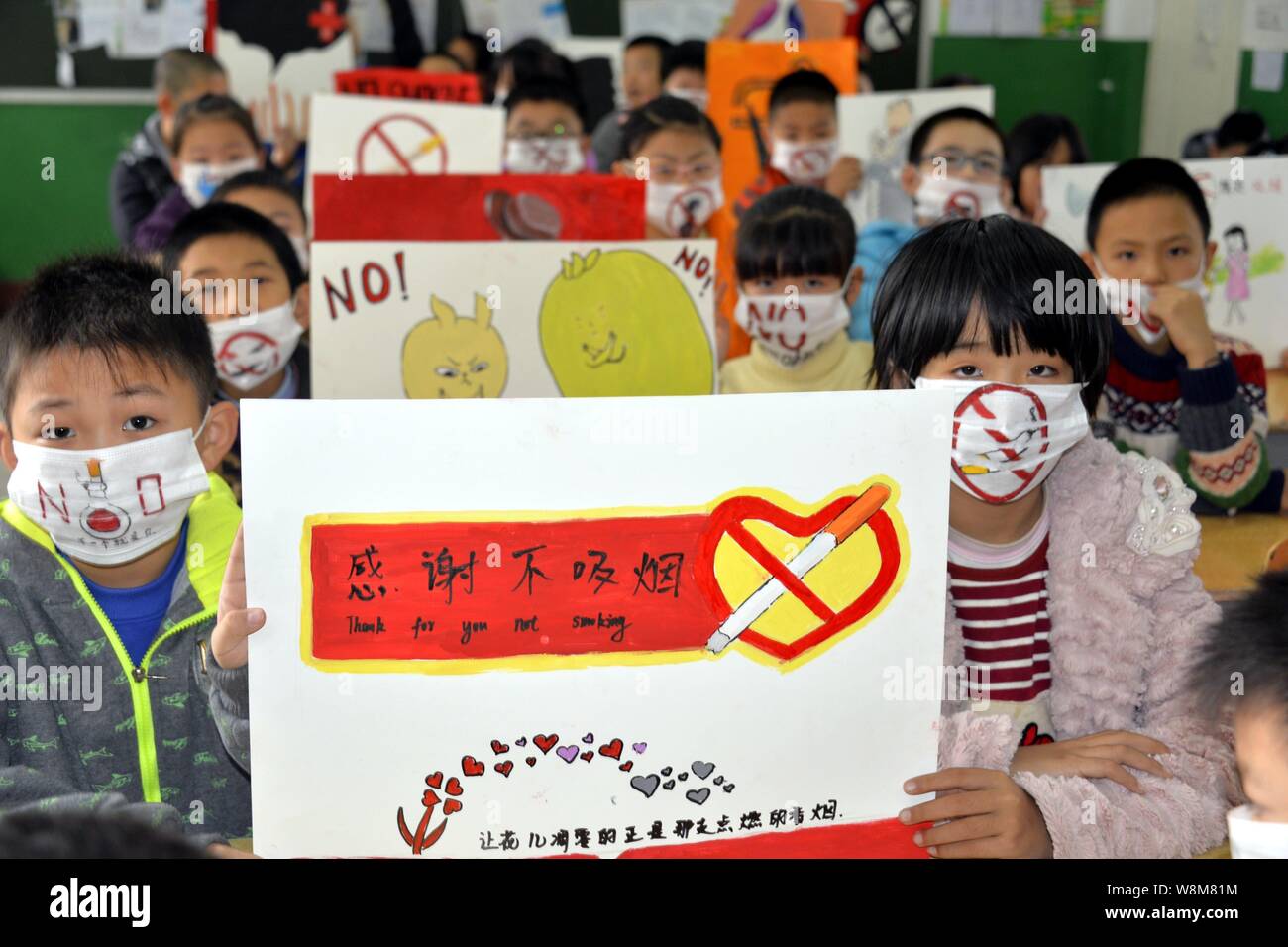 --FILE--Young Chinese students show their face masks with No-Smoking ...
