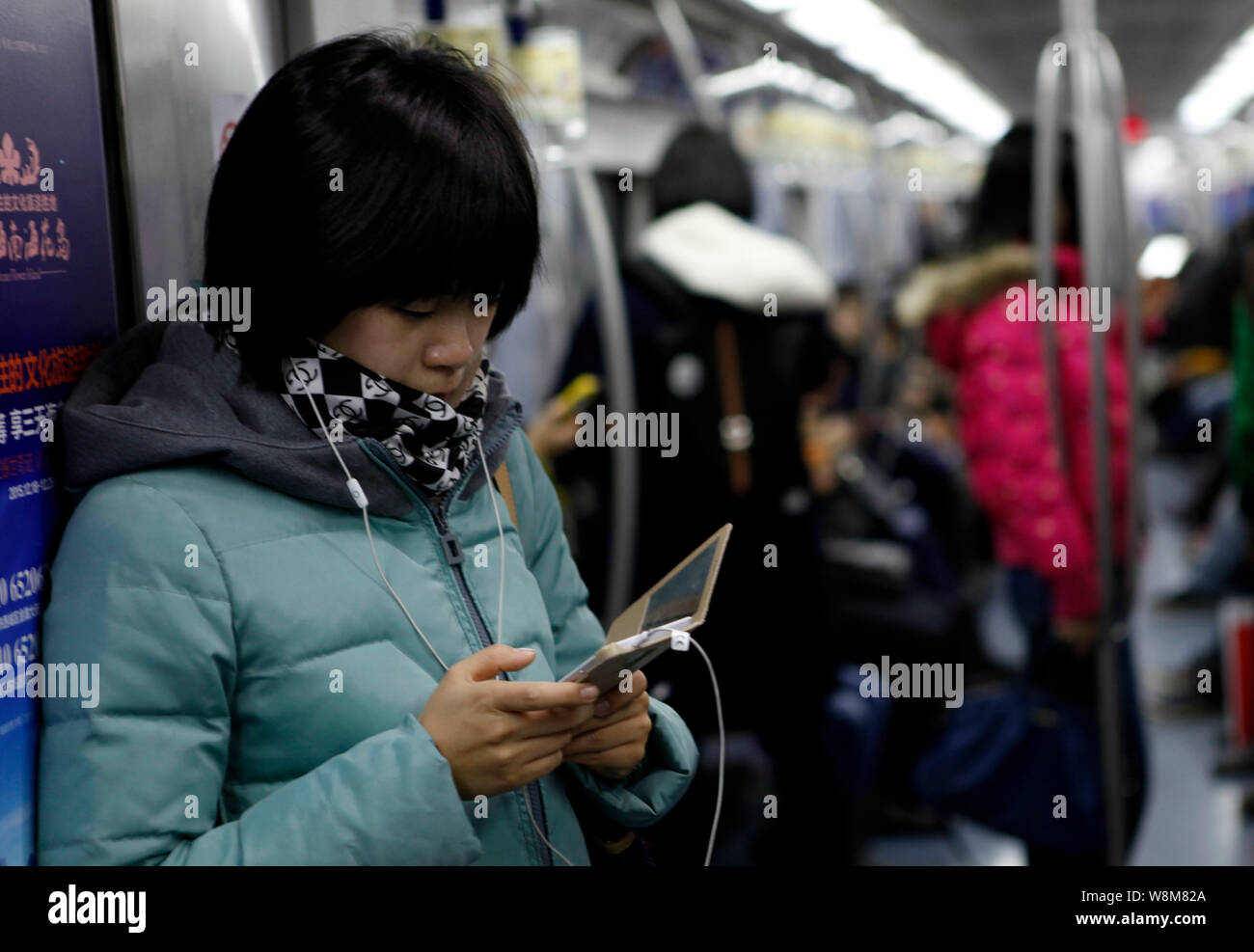 --FILE--A Chinese passenger uses her smartphone to surf the Internet on ...