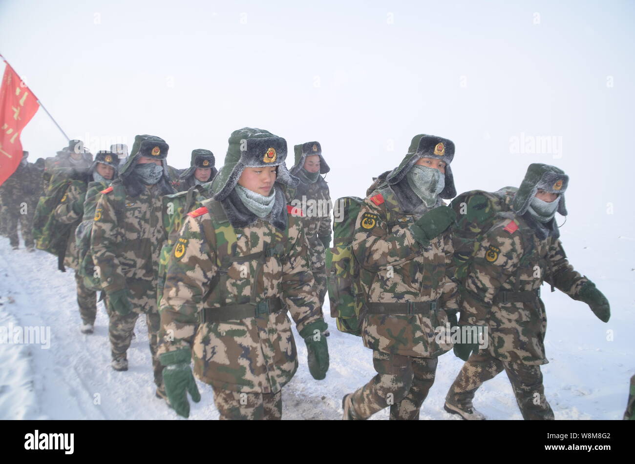 Chinese paramilitary policemen march on the snow towards the forest of ...