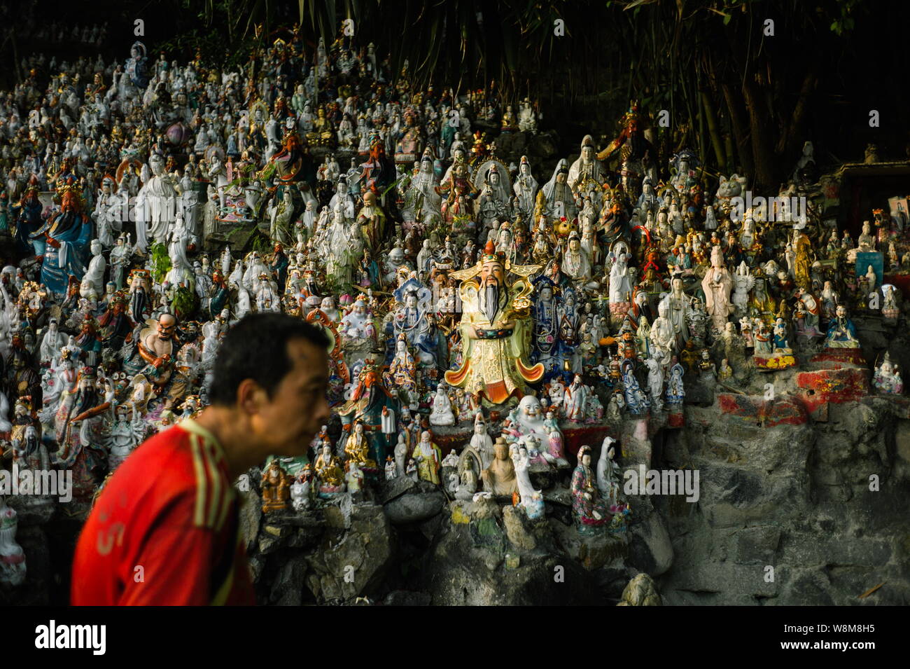 A man walks by hundreds of Buddha statuettes at Pok Fu Lam residential ...