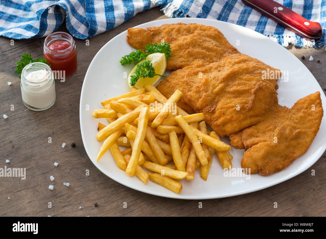 Chicken schnitzel. Breaded chicken schnitzel fries potatoes and sauces ...