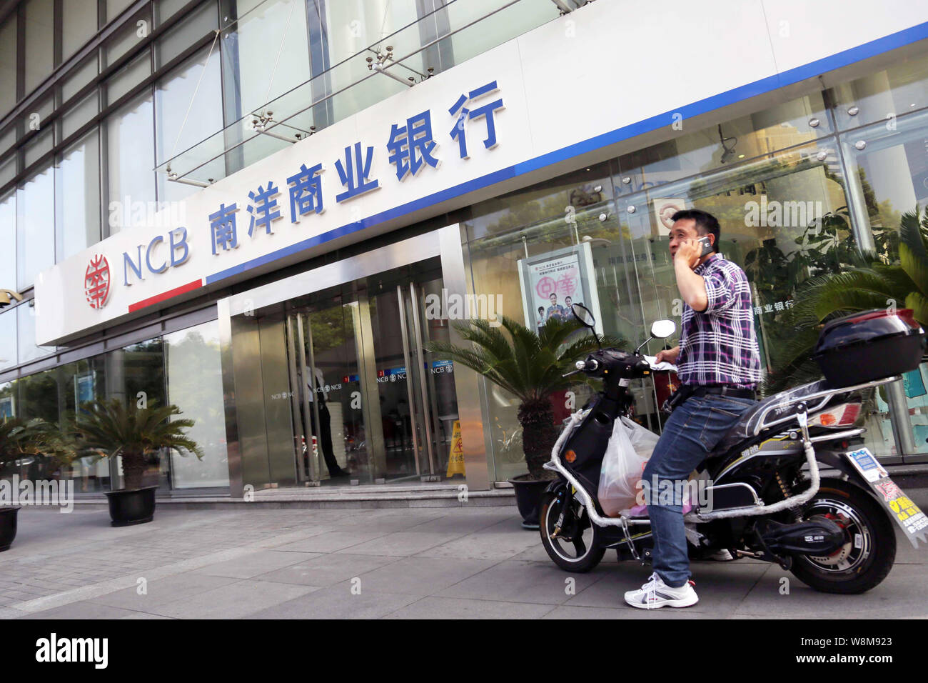 --FILE--A Chinese electric bike rider talks on his mobile phone in ...