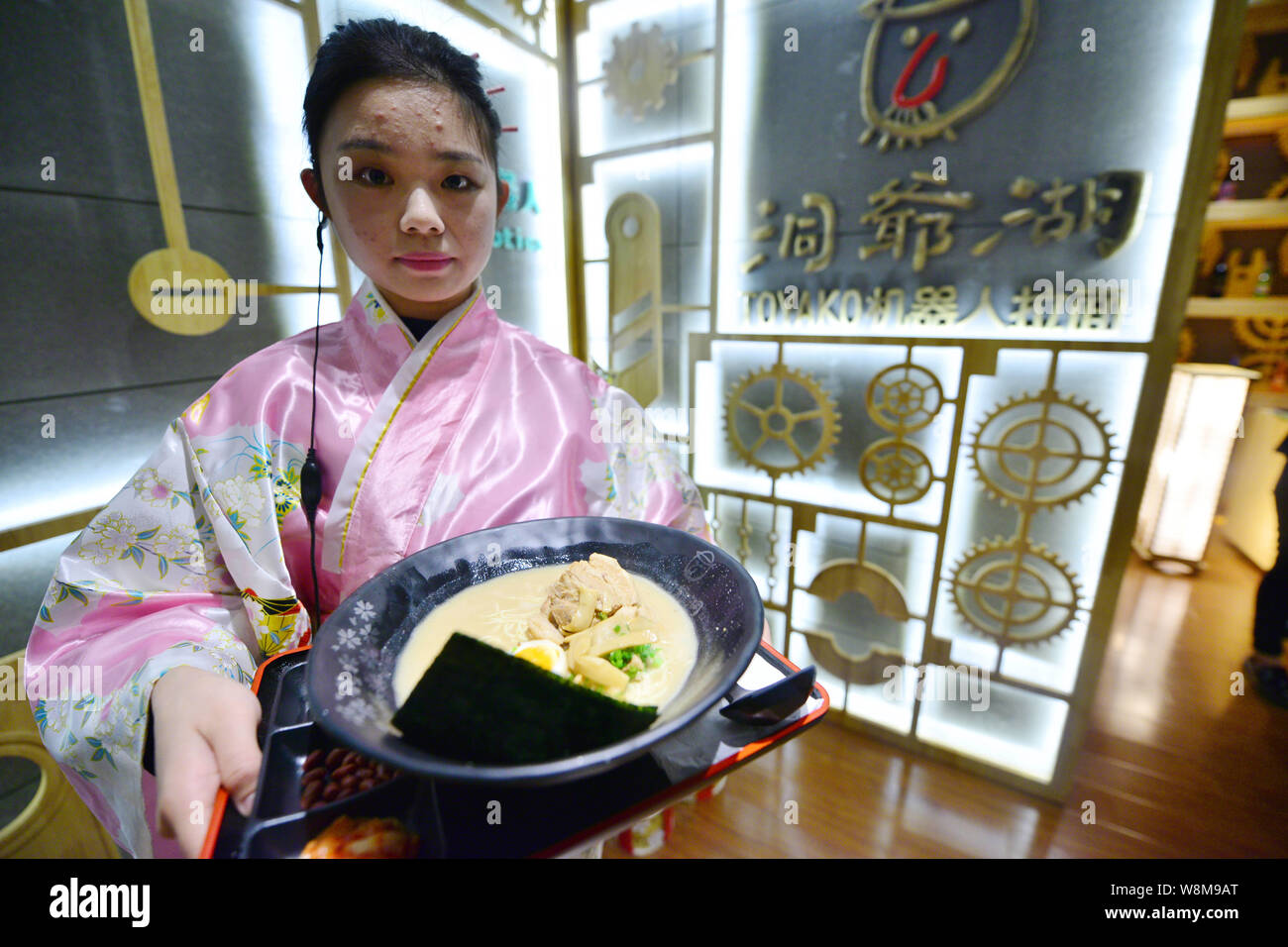 A waitress serves a bowl of noodles cooked by robots Koya and Kona at a ...