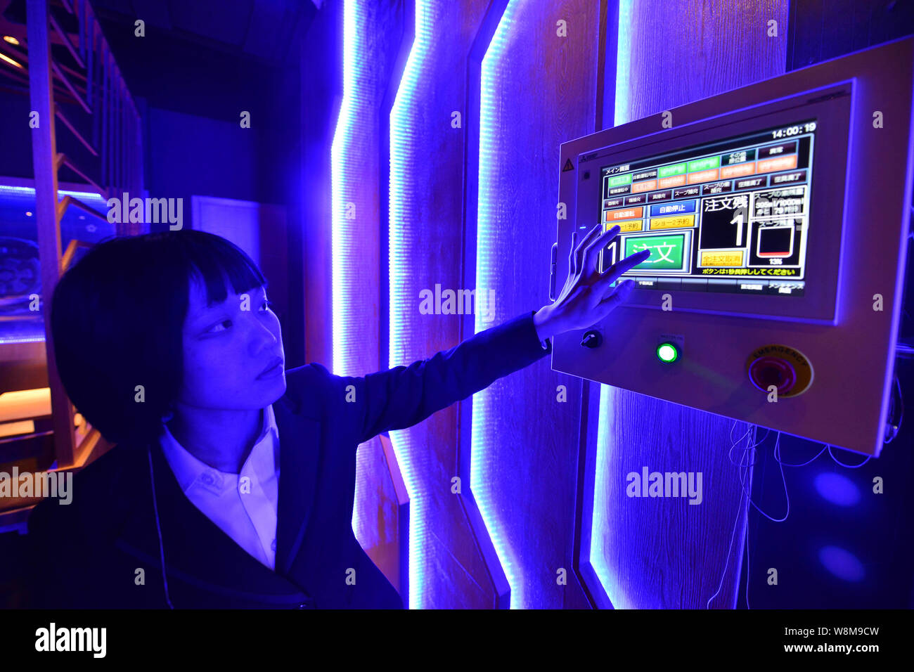 A waitress places an order to make robots Koya and Kona cook noodles at ...