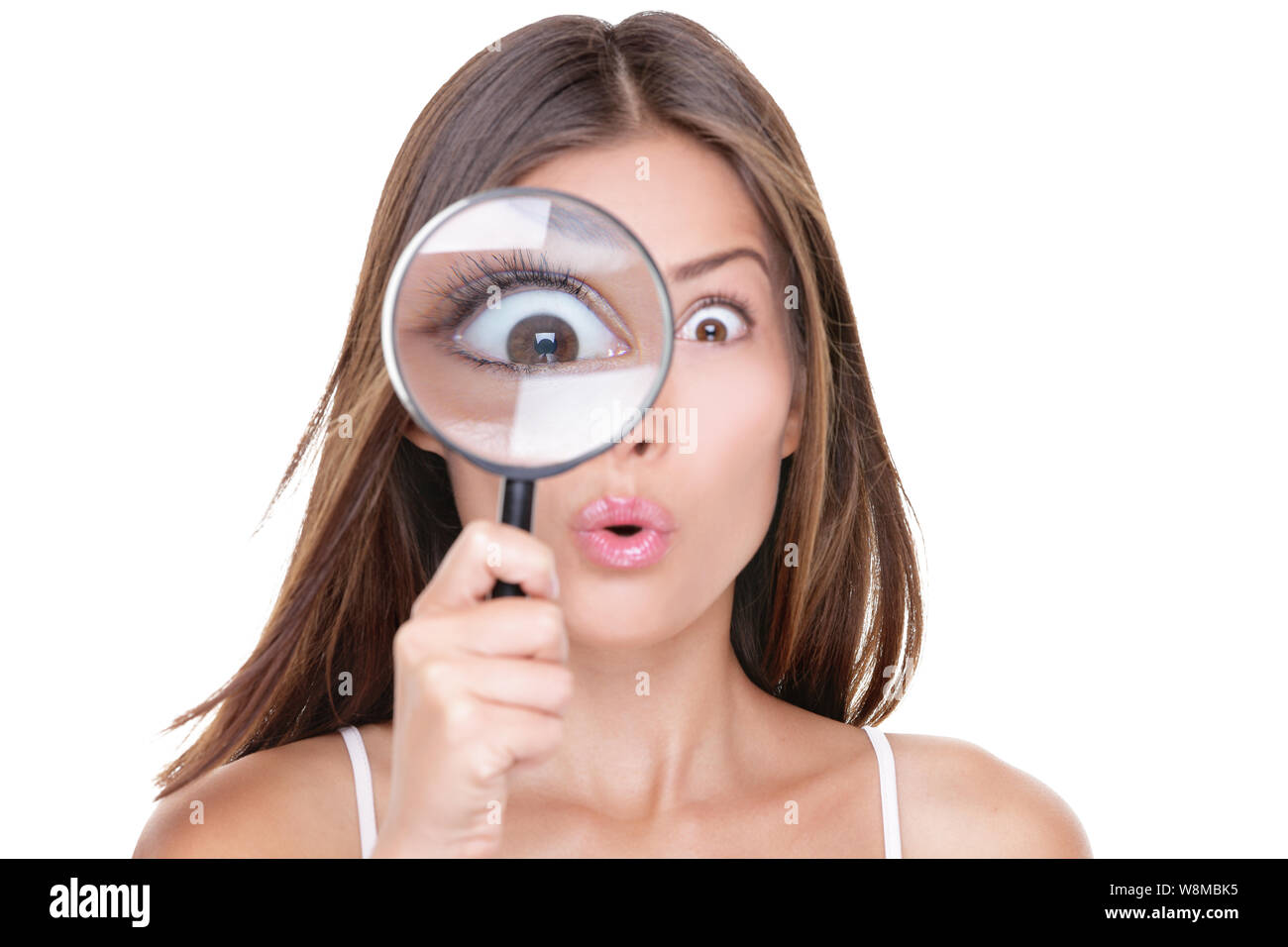 Funny expression. Shocked woman looking through a magnifying glass ...