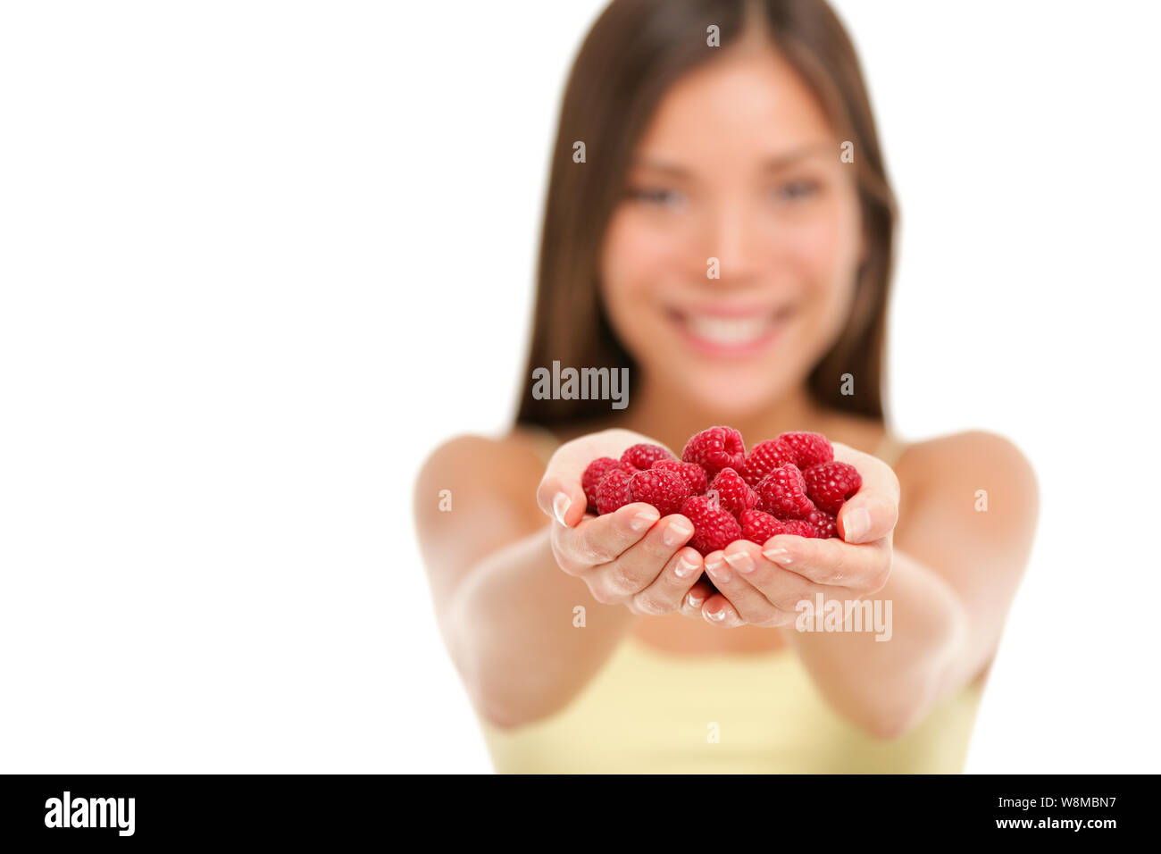 Woman holding fresh raspberries in hands closeup isolated on white ...