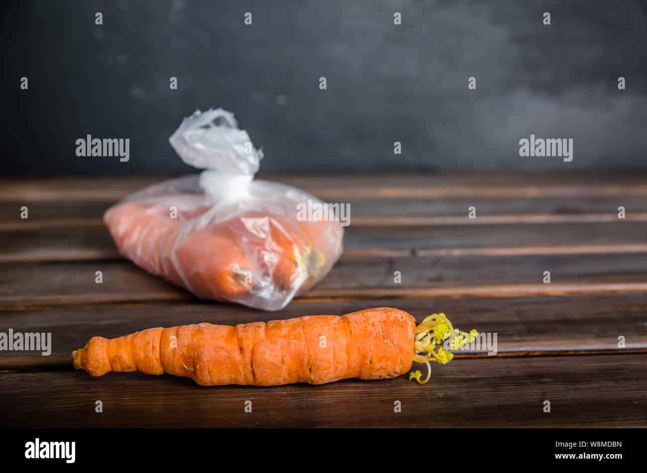 concept plasic free carrots in a plastic bag on a brown background with ...