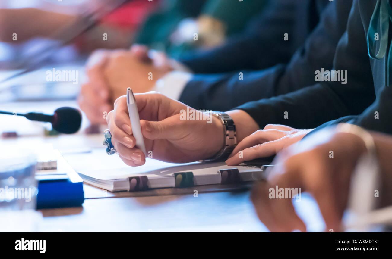 closeup shot of business people hands using pen while taking notes on ...