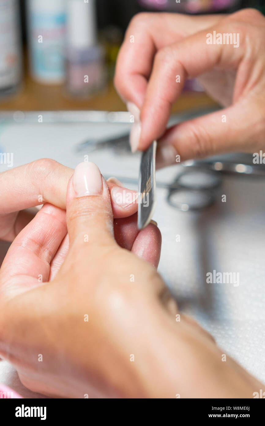 Close up woman hand while process of manicure in nail shop. Beautiful ...