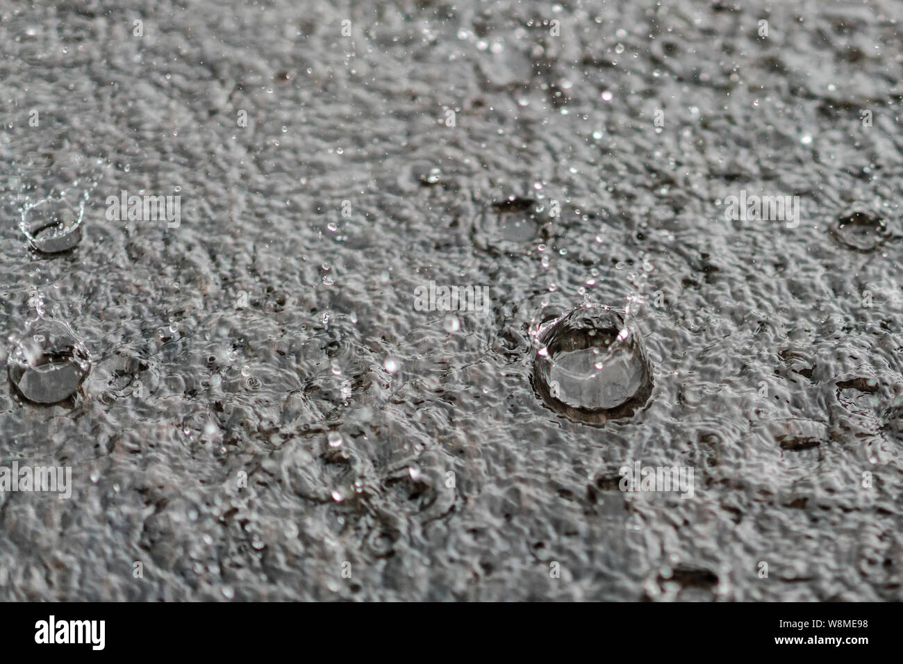 rain gray background. Drops on a puddle Stock Photo - Alamy