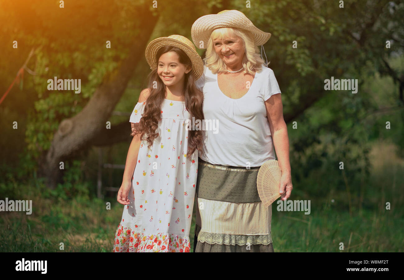 Grandmother And Granddaughter Are Standing In The Beautiful Garden ...