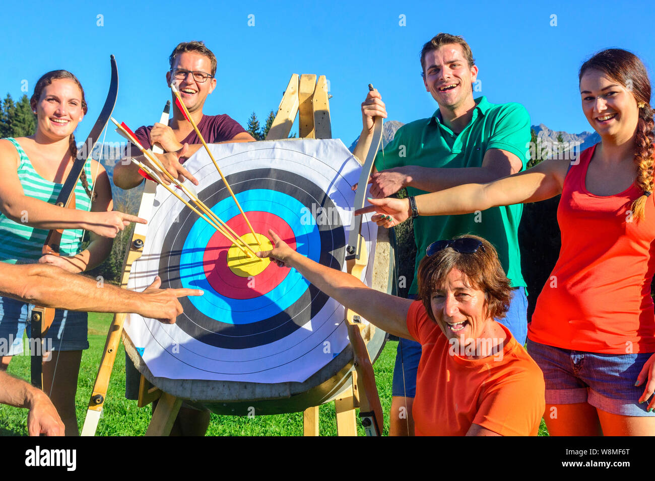 Group of happy people doing archery Stock Photo - Alamy