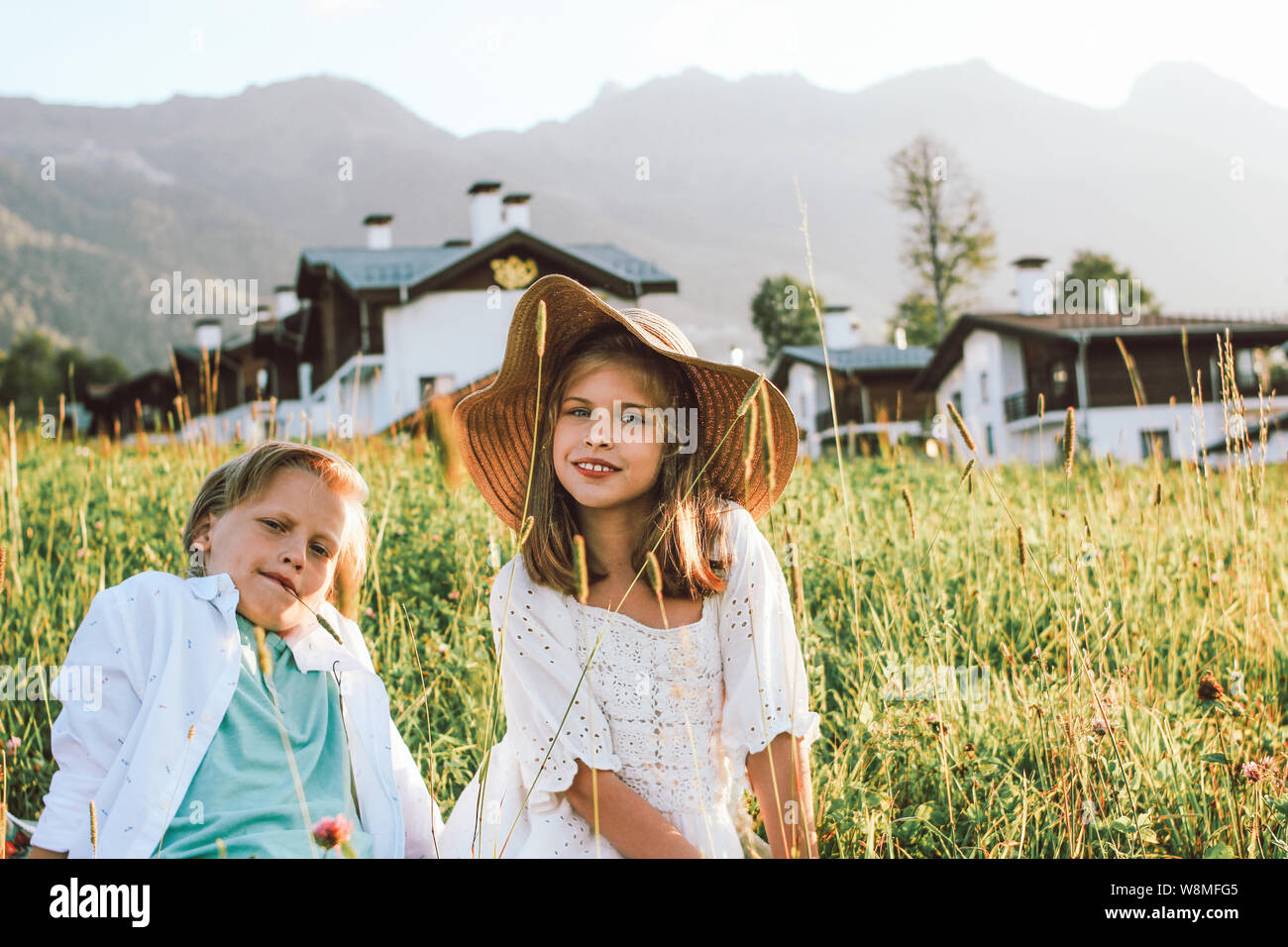 Children brother and sister friends sitting in grass against the ...